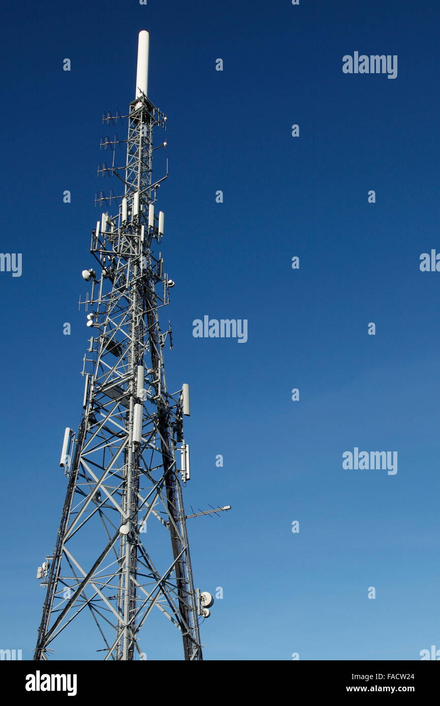 A TV and radio mast against a blue sky Stock Photo - Alamy