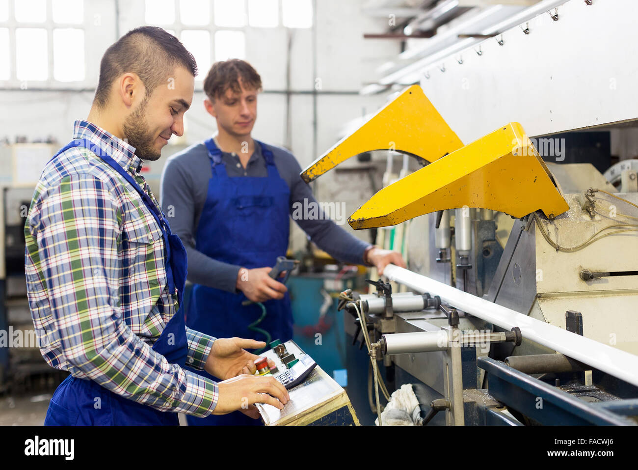 Two positive employes do his job on a machine in plant Stock Photo - Alamy