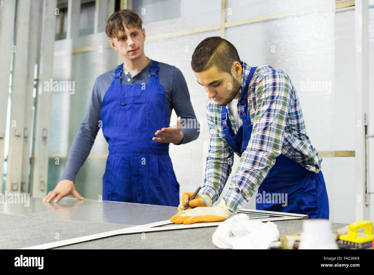 Two careful workmen cutting glass for windows at workshop Stock Photo ...