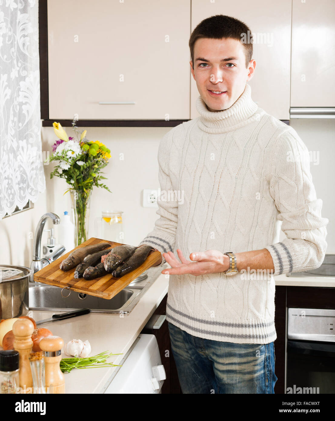 Handsome guy with trout at home kitchen Stock Photo - Alamy