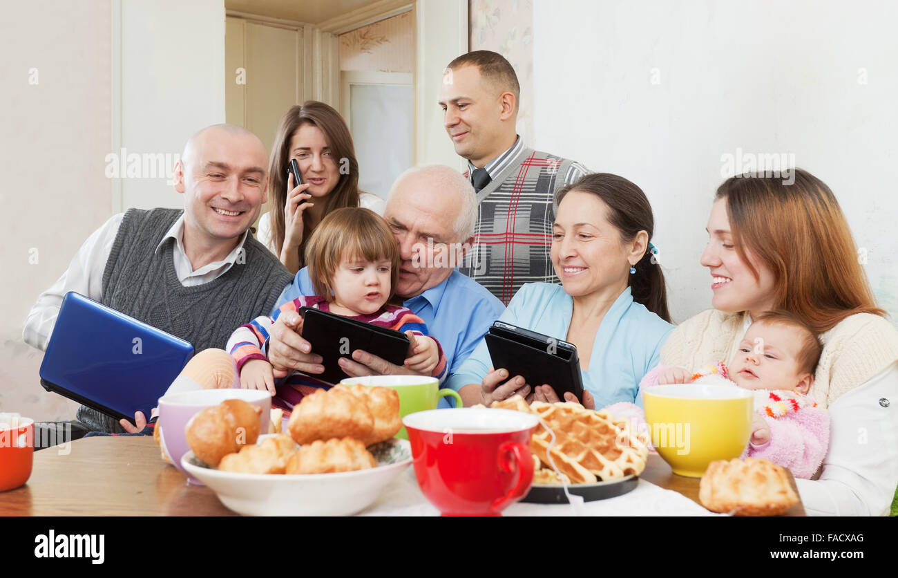 Portrait o Happy multigeneration family using electronic devices over ...