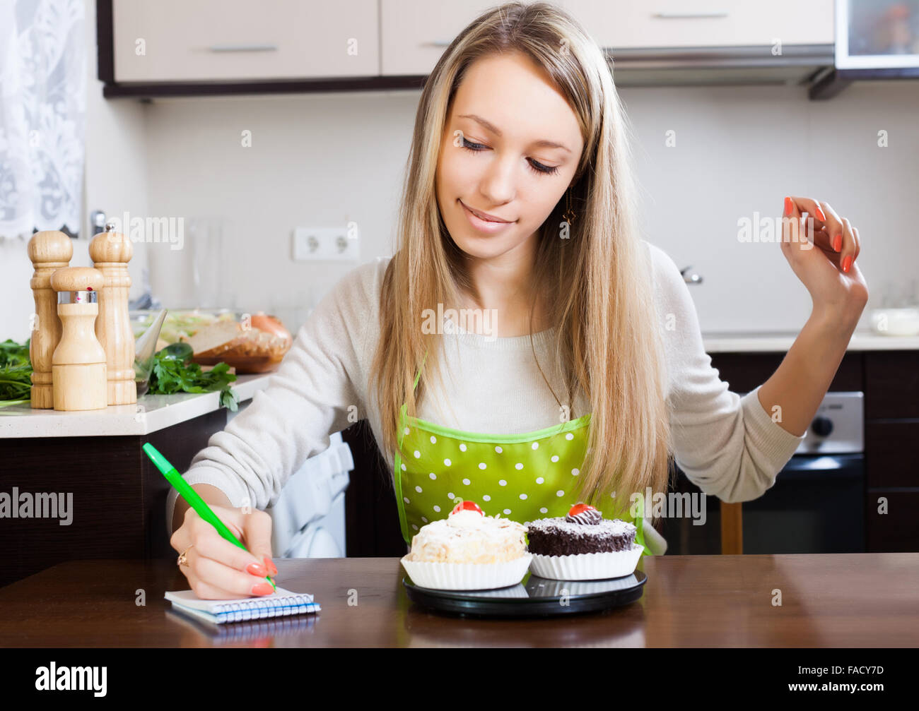 Woman weighing cakes on kitchen scales Stock Photo - Alamy