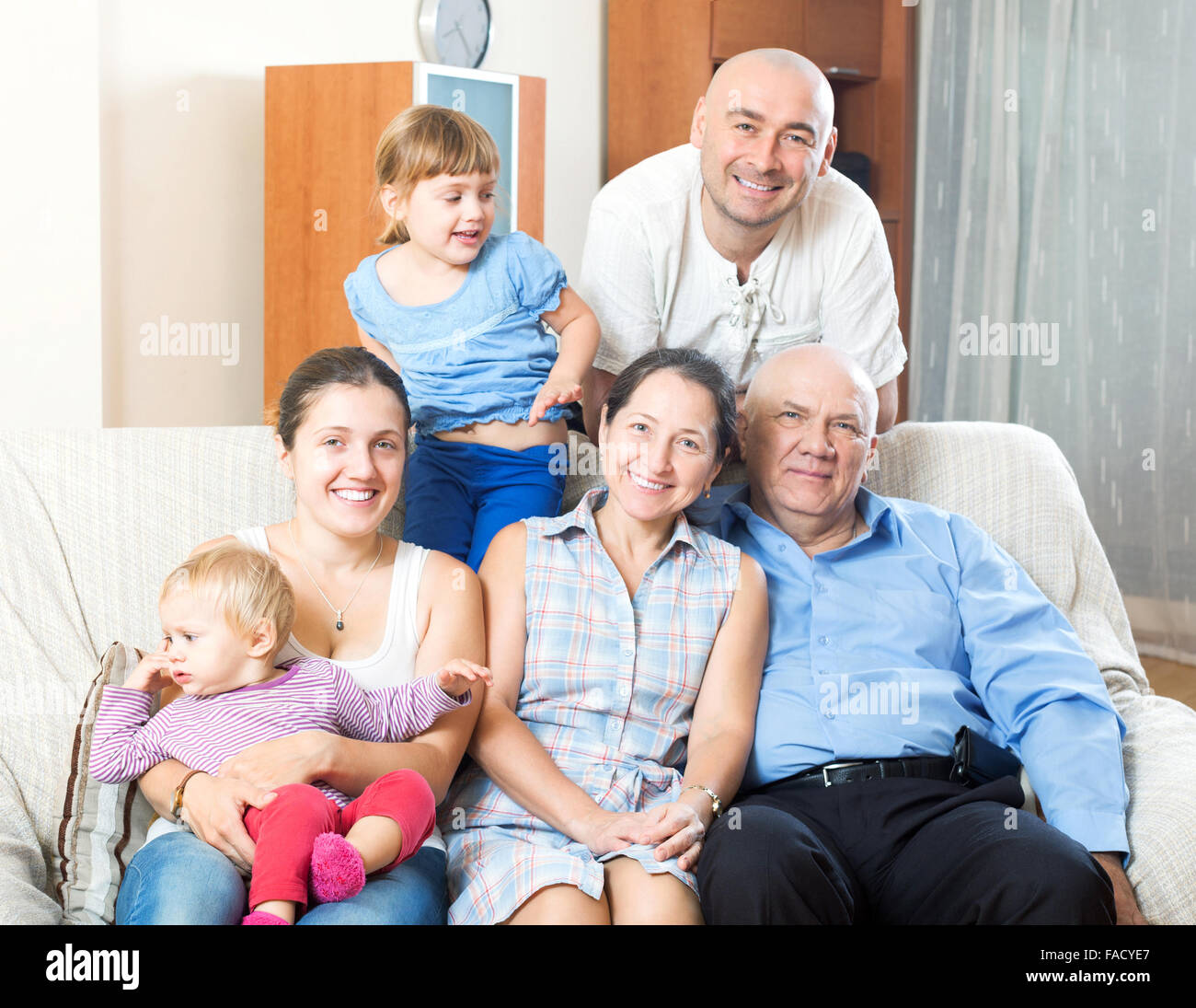 Portrait of happy multigeneration family with little children in home ...