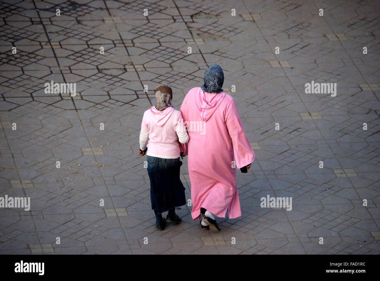 Mother and daughter, wearing traditional clothing,walking in Morocco ...