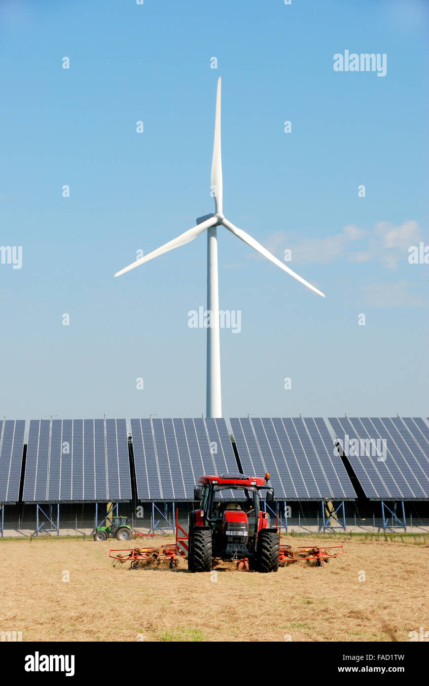 Solar plant with wind turbine at a farm in the Netherlands.In front two ...