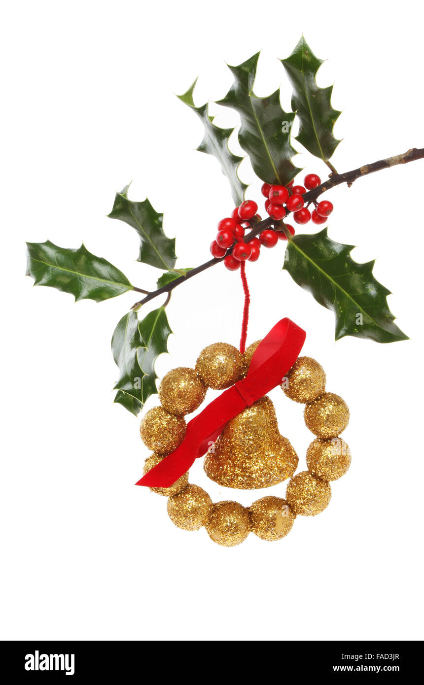Bell and ball gold glitter Christmas decoration hanging in a holly ...