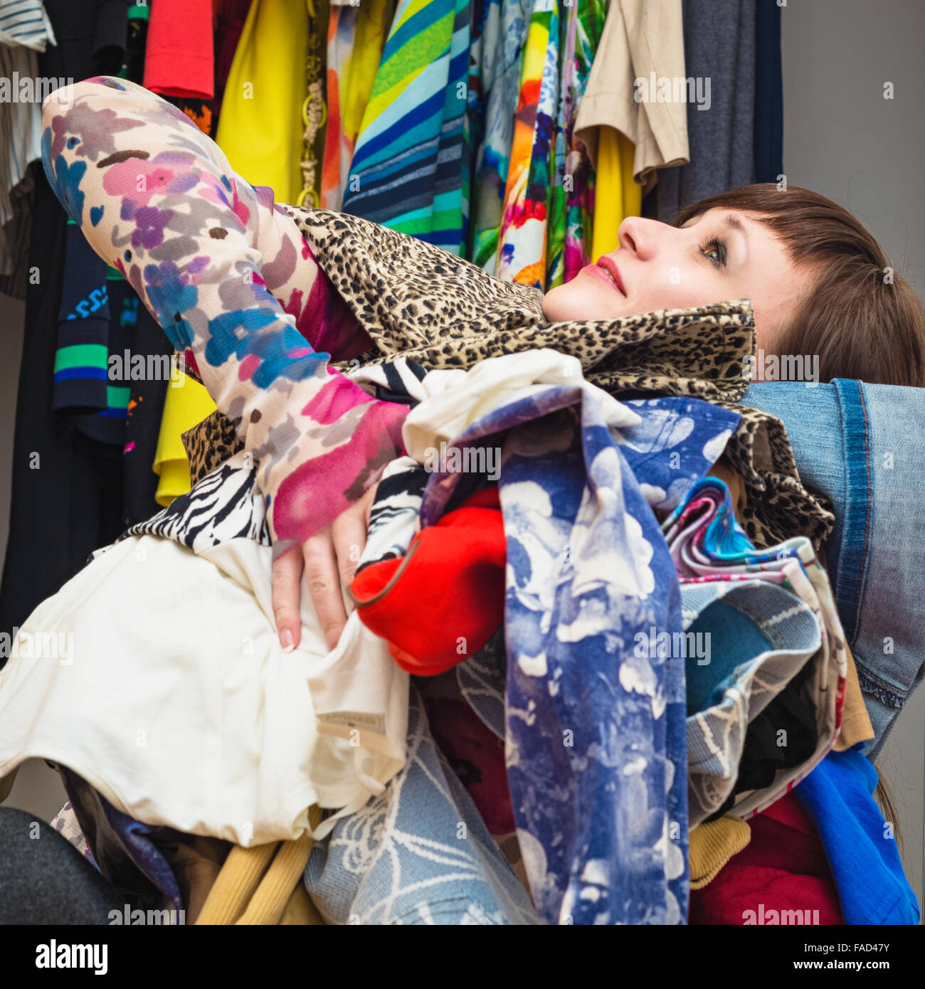 Portrait of a beautiful young woman with clothes in hands Stock Photo ...