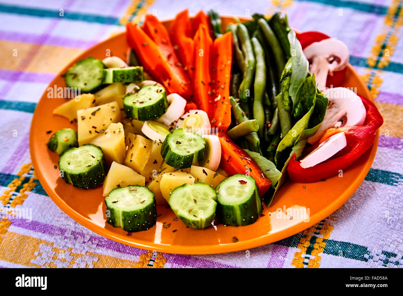 Ladle of steamed freshly harvested young vegetables including crinkle ...