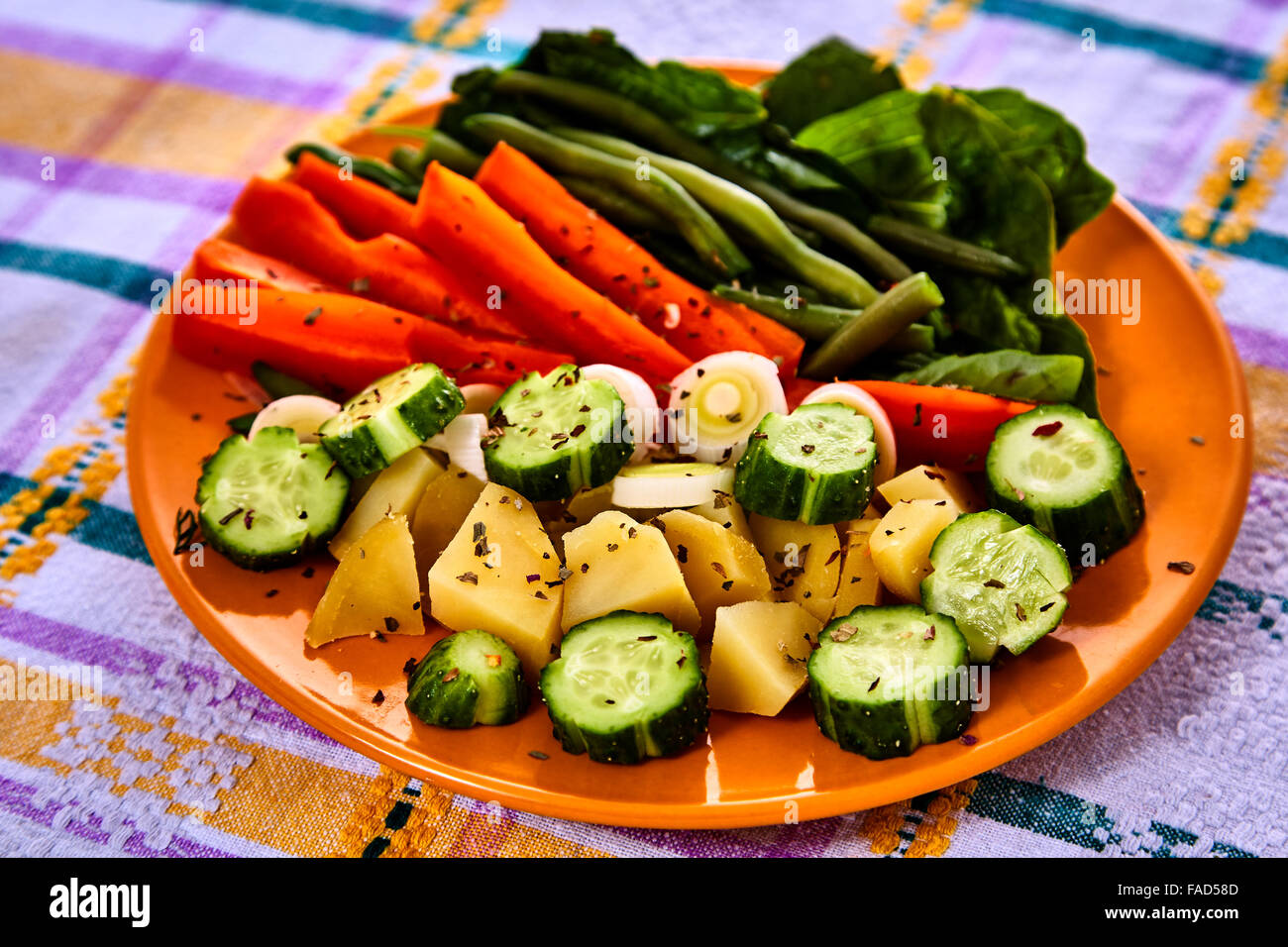 Ladle of steamed freshly harvested young vegetables including crinkle ...