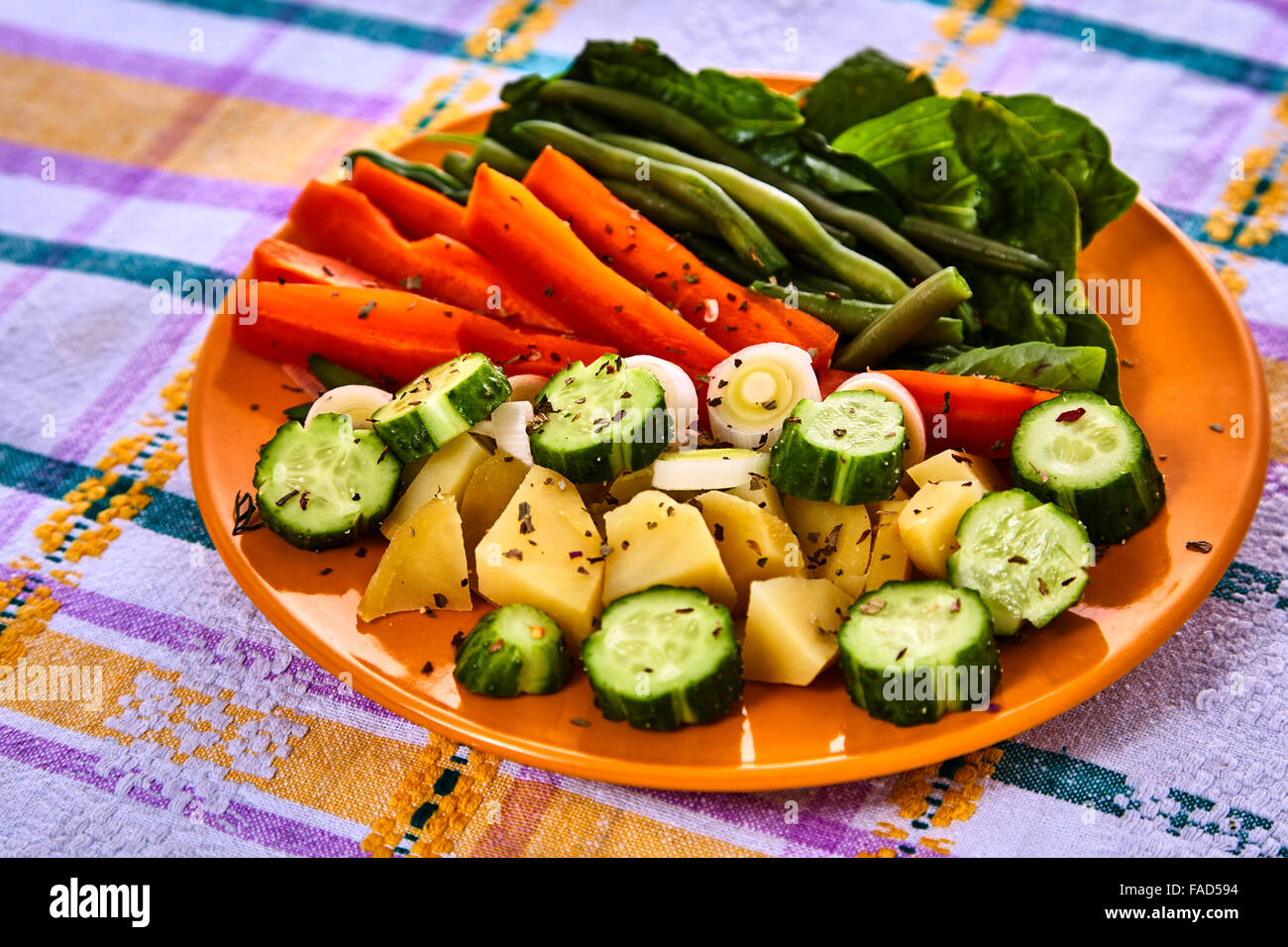 Ladle of steamed freshly harvested young vegetables including crinkle ...