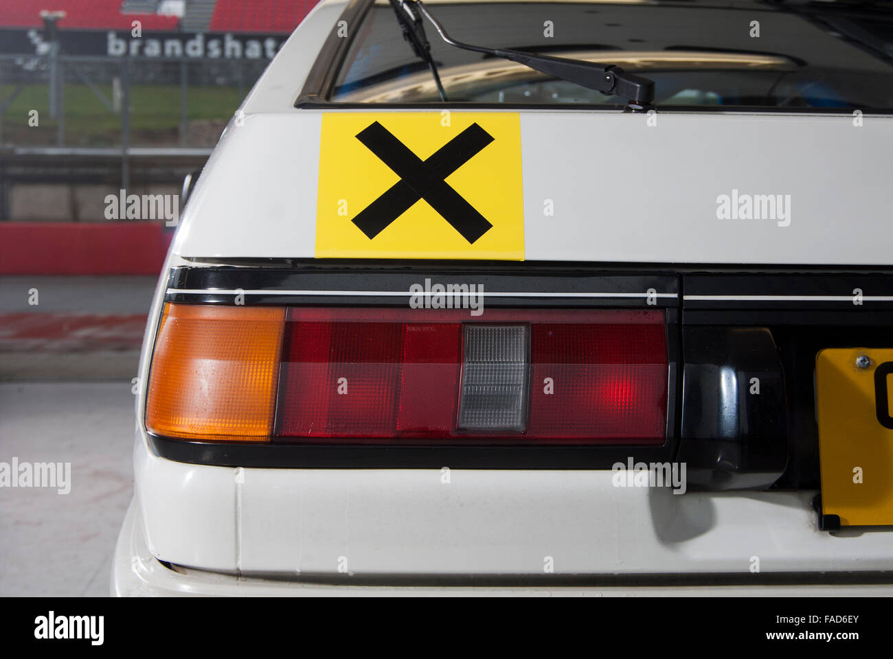 Novice sticker on a car at a race track, black X on yellow square on a ...