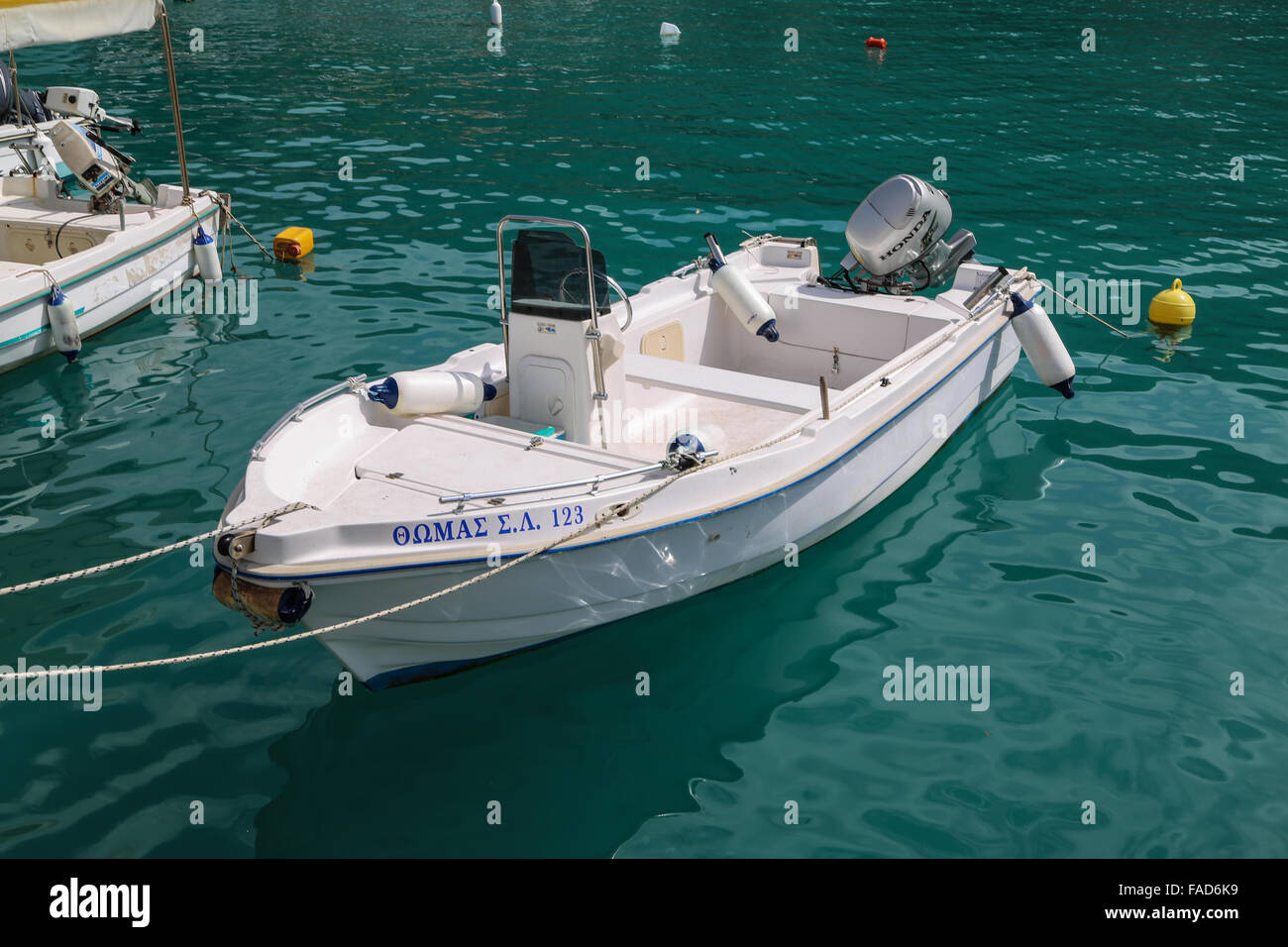 Small boat floating in the marina water in Greece Stock Photo - Alamy