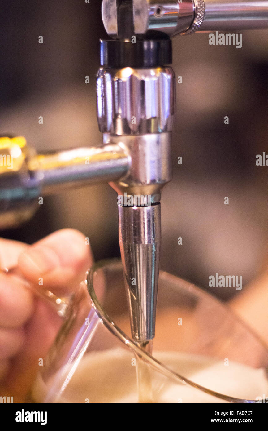 Lager draft beer pump and barman pulling pint of beer into glass in ...