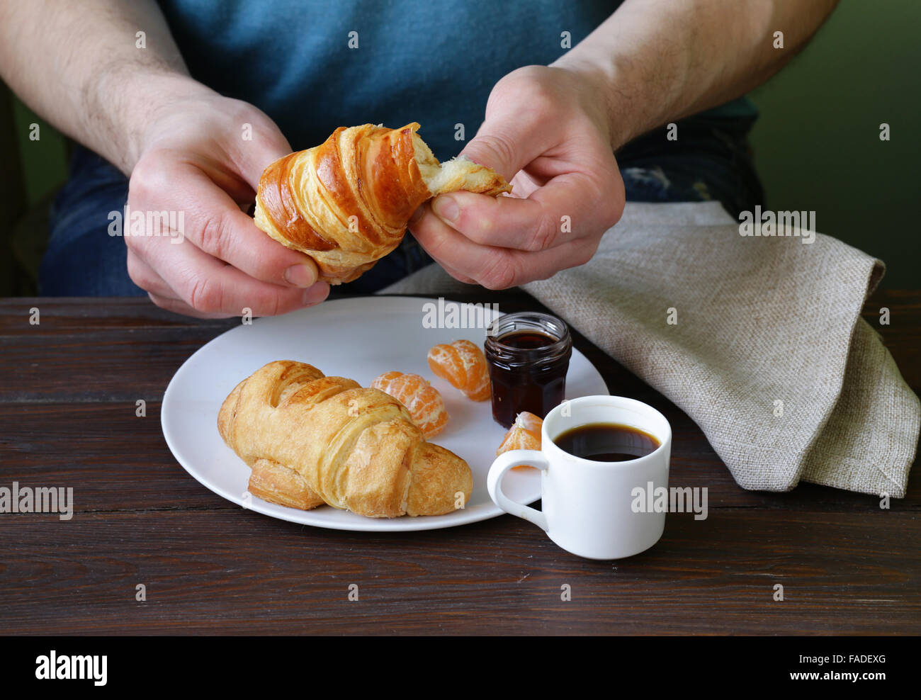 man eating a croissant with jam for breakfast Stock Photo - Alamy