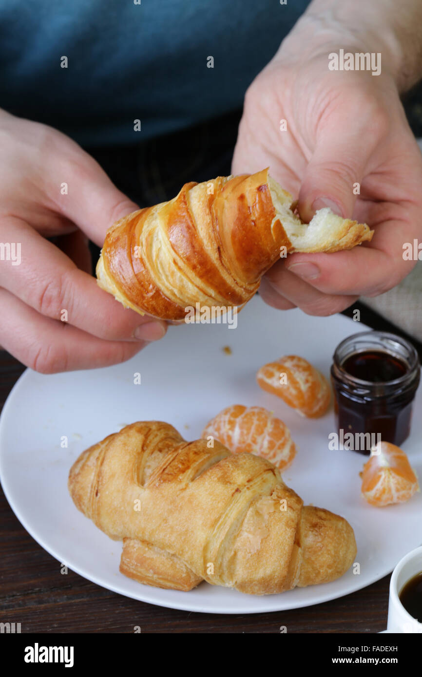man eating a croissant with jam for breakfast Stock Photo - Alamy
