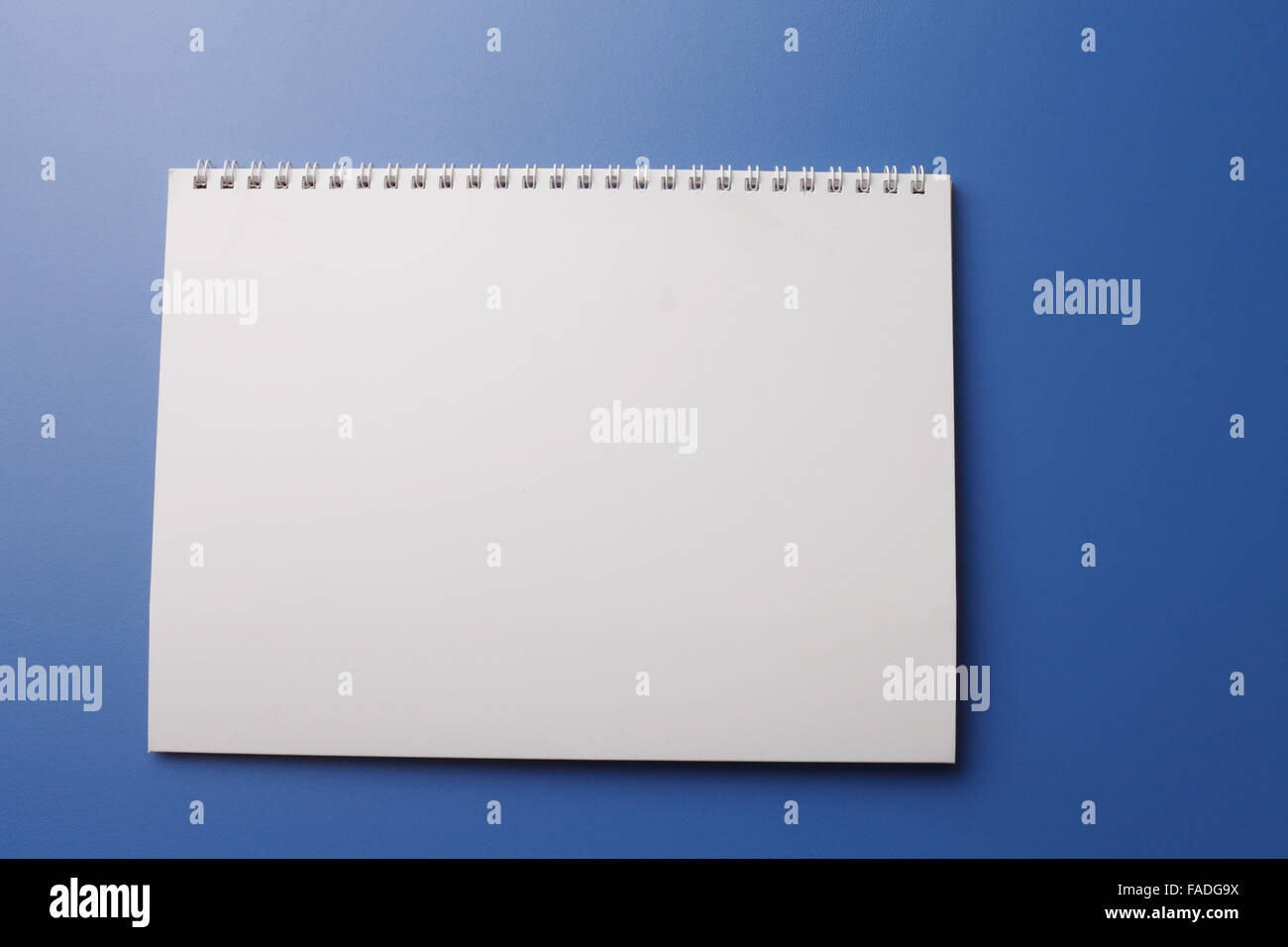 spiral note on the blue background Stock Photo - Alamy