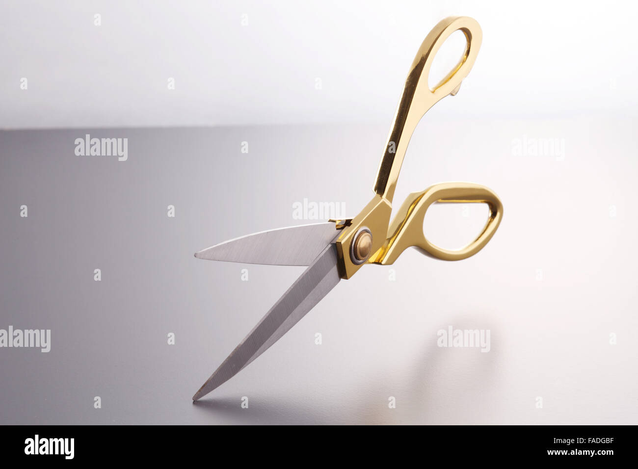 Open steel scissors with golden handles Stock Photo - Alamy