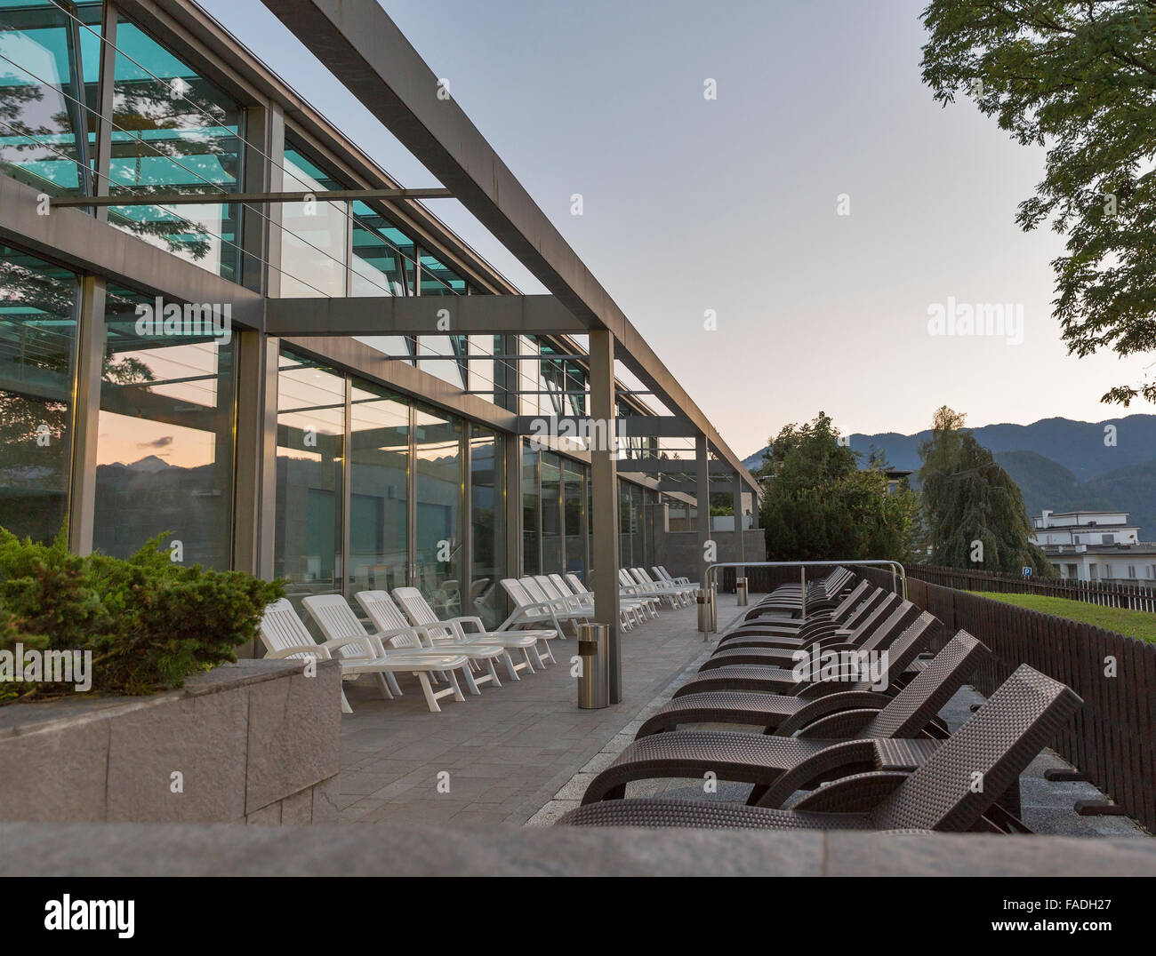 Sunset terrace with sunbeds in a rows near the outdoor swimming pool at ...