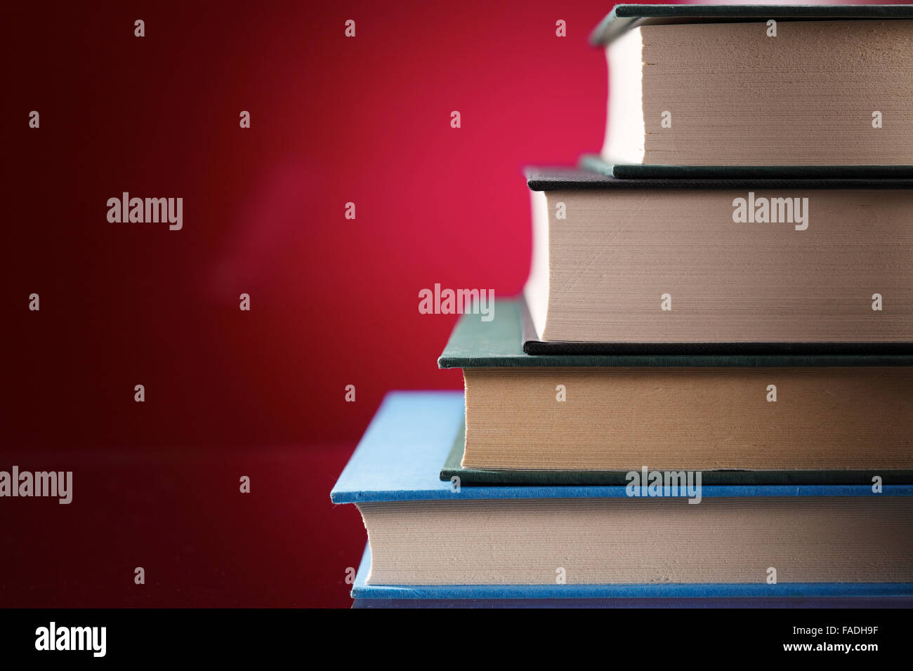 stack of the books on the red background Stock Photo - Alamy