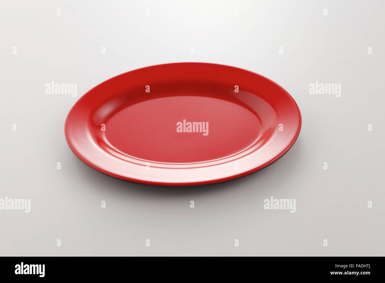 Empty red plate on the white background Stock Photo - Alamy