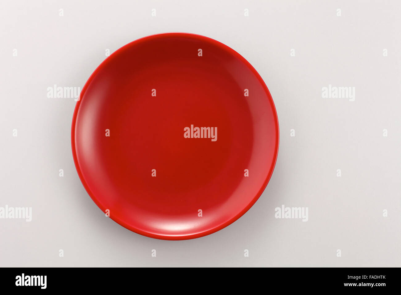 Empty red plate on the white background Stock Photo - Alamy