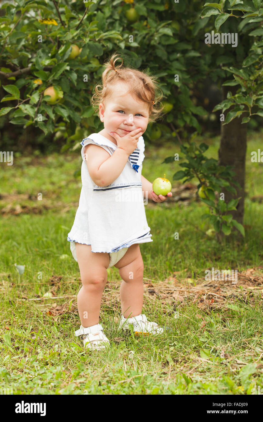 Baby girl under the apple tree Stock Photo - Alamy
