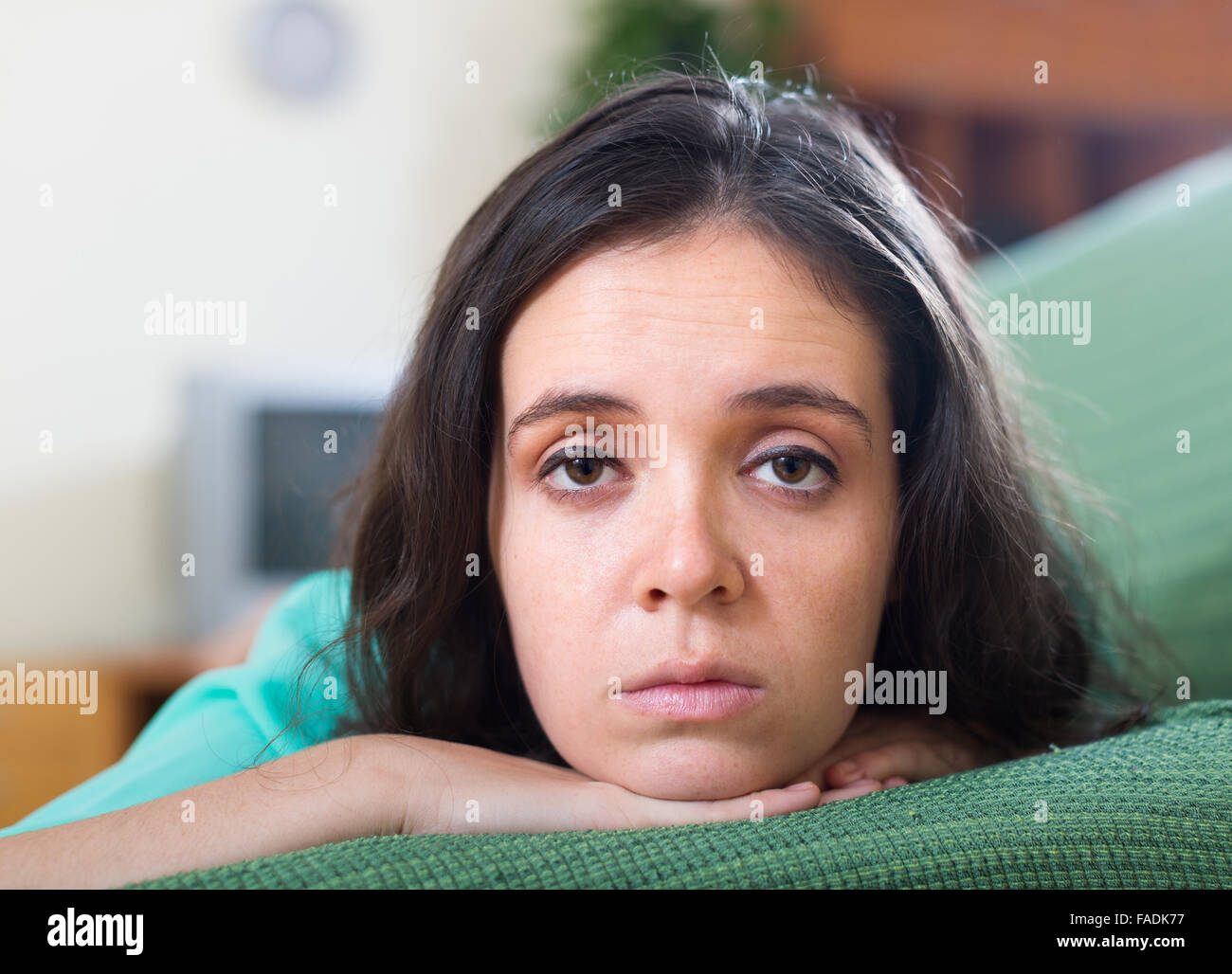Unhappy lonely young brunette woman crying on couch at home Stock Photo ...