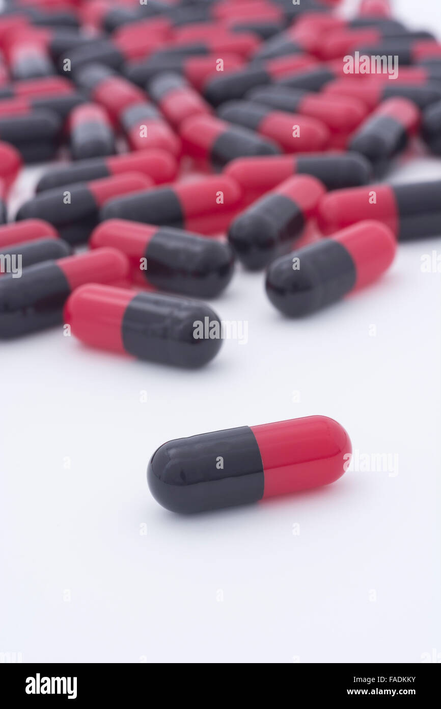 Close-up of red and black pills - capsule form made of gelatin. Big ...