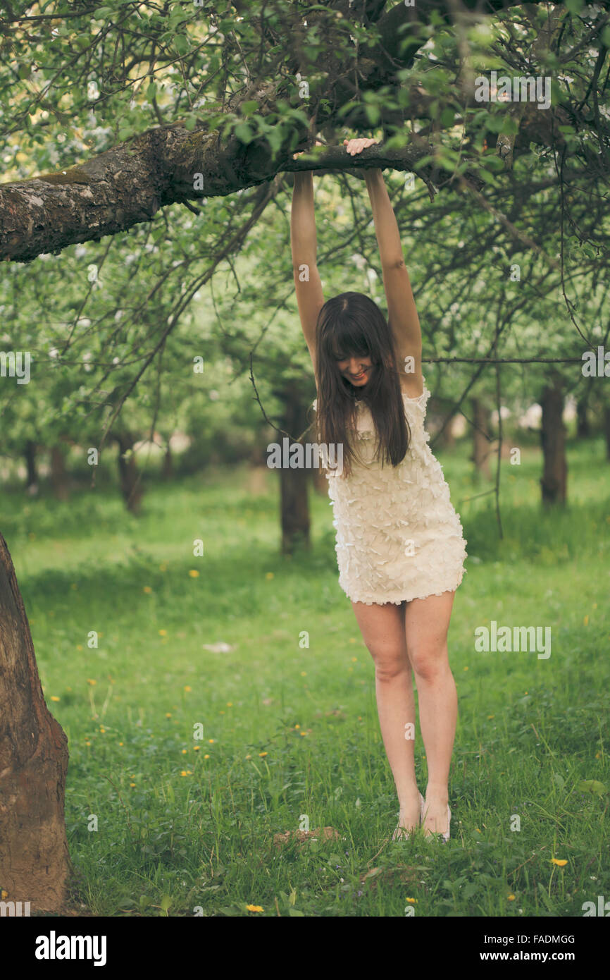 Girl clings to a tree branch Stock Photo - Alamy