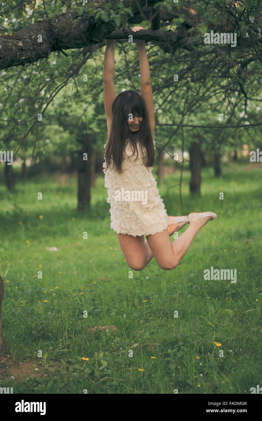 Girl clings to a tree branch Stock Photo - Alamy