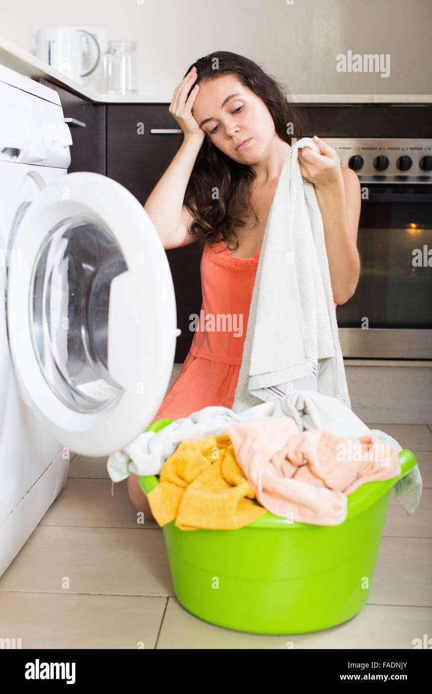 Home laundry. Unhappy girl doing housework at home Stock Photo - Alamy