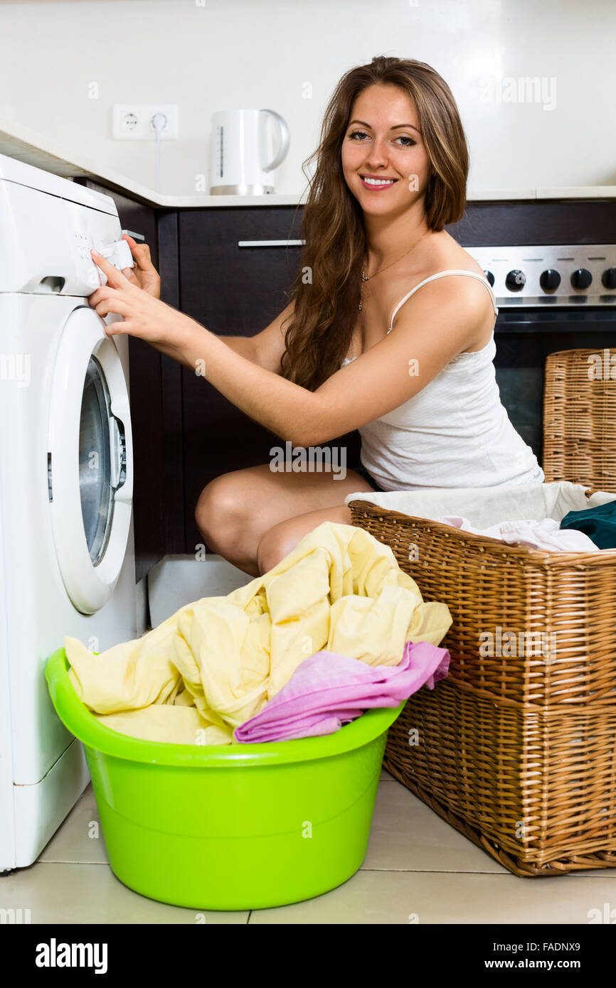 Happy woman washing clothes in washer at home Stock Photo - Alamy