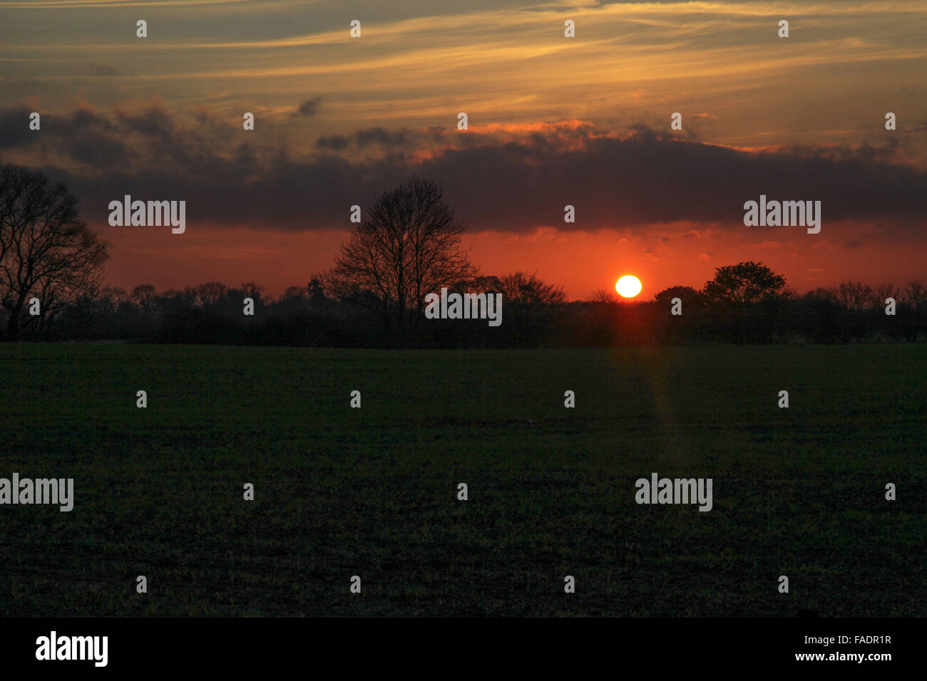 Clouds at sunset, almost a silhouette. Sun light breaking through the ...