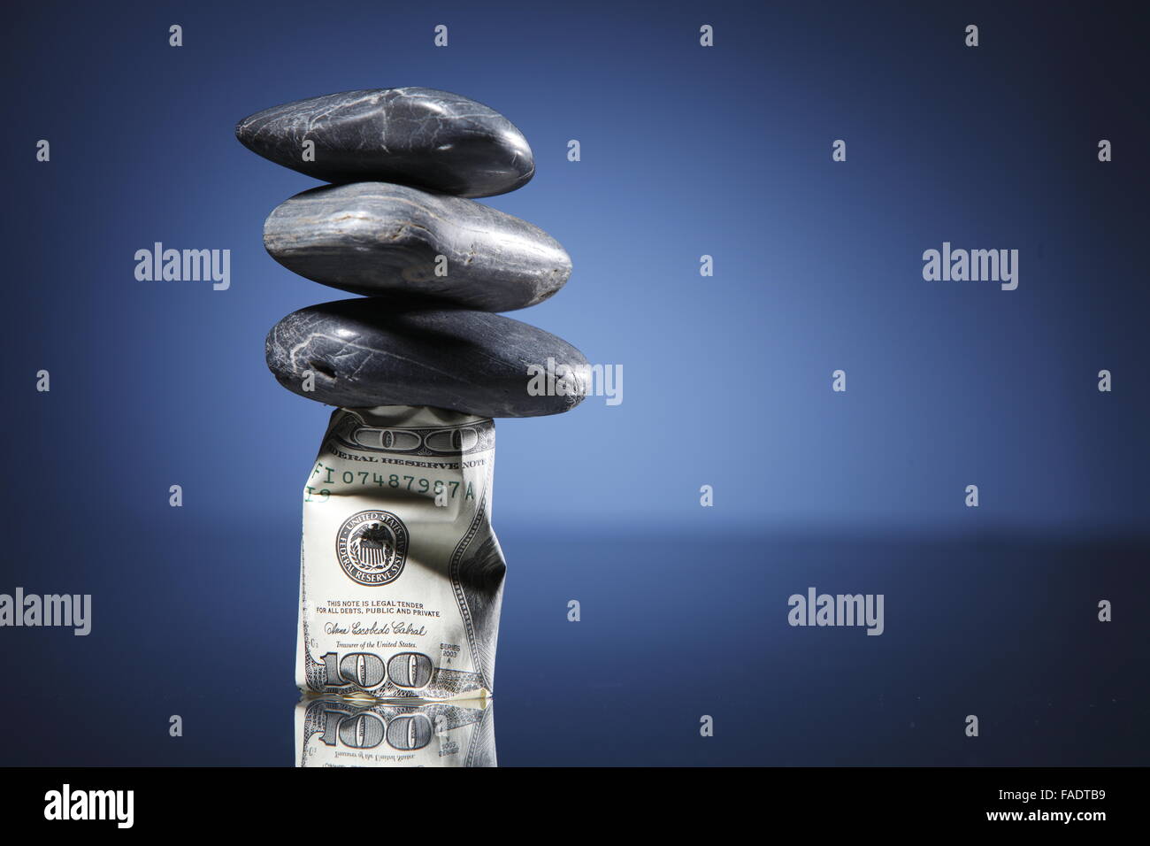 money stack under the stone Stock Photo - Alamy