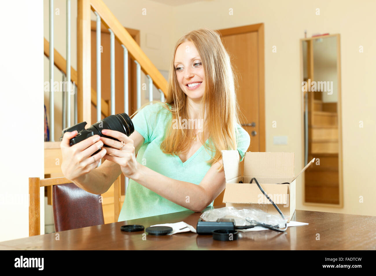 Happy woman unpacking new digital camera at home alone Stock Photo - Alamy