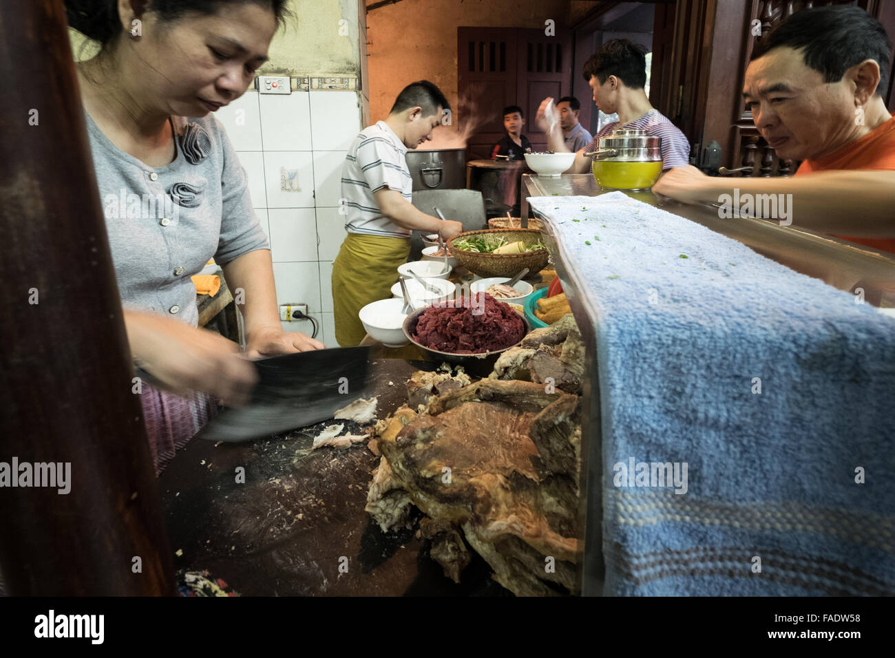 Staff preparing bowls of Pho Bo (beef noodle soup) at the iconic Pho ...