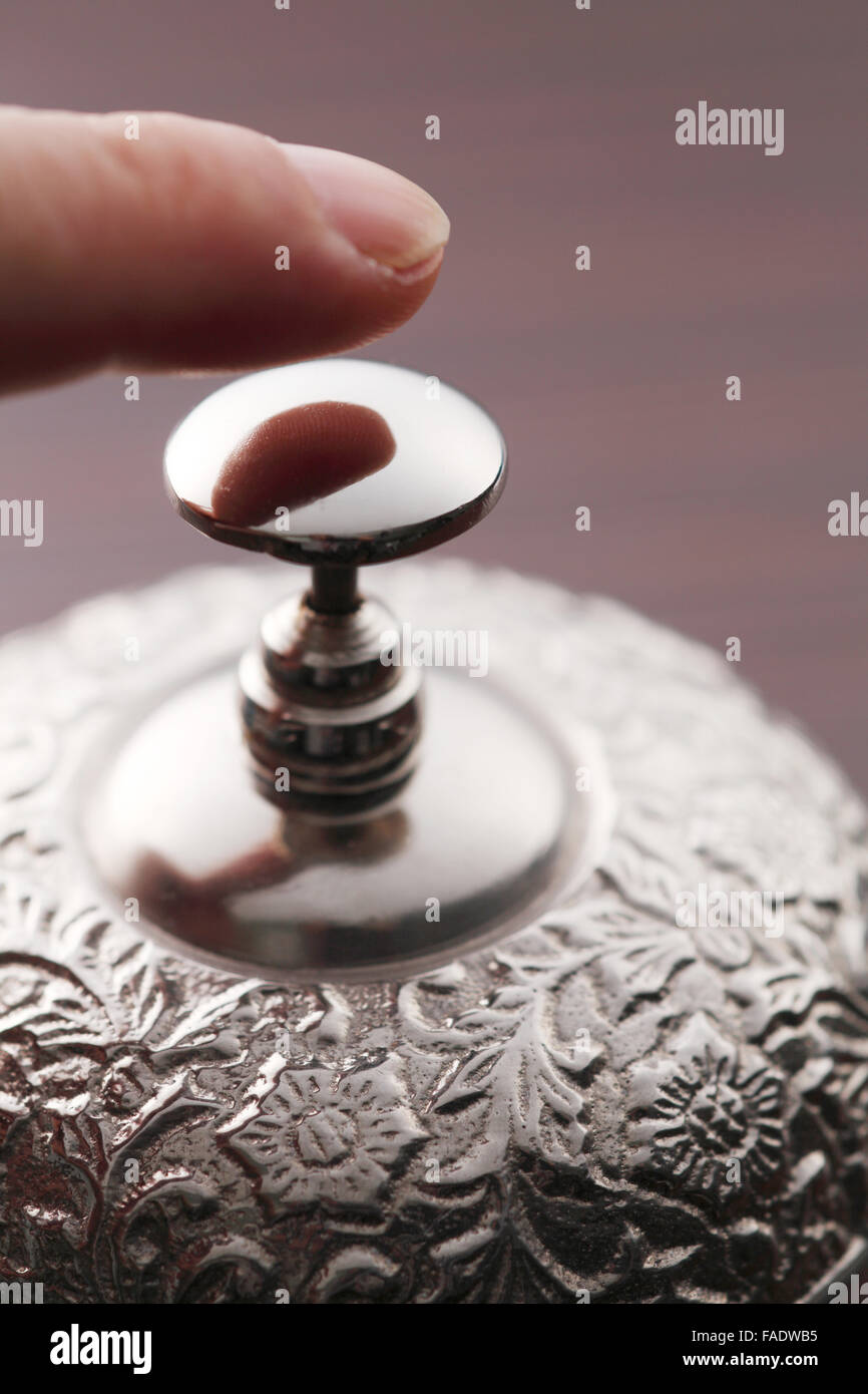 Hand pressing a service bell Stock Photo - Alamy