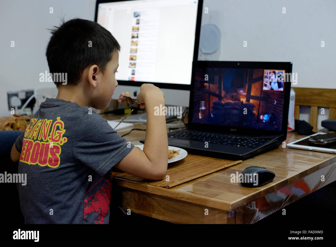 Boy laptop eating hi-res stock photography and images - Alamy