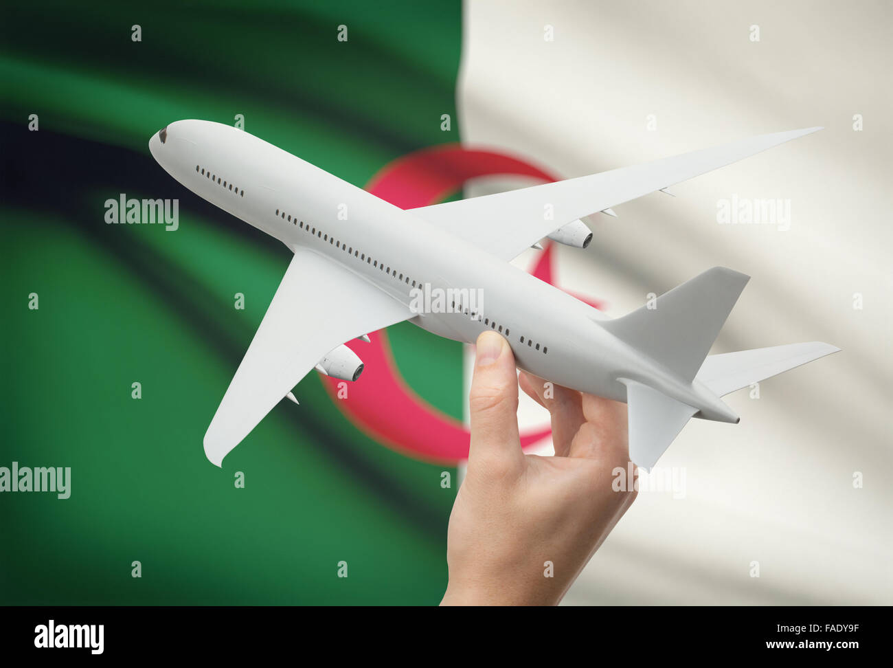 Airplane in hand with national flag on background - Algeria Stock Photo ...