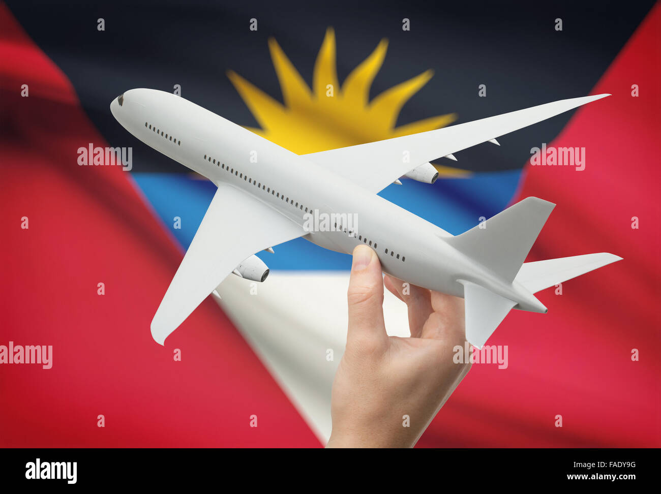 Airplane in hand with national flag on background - Antigua and Barbuda ...