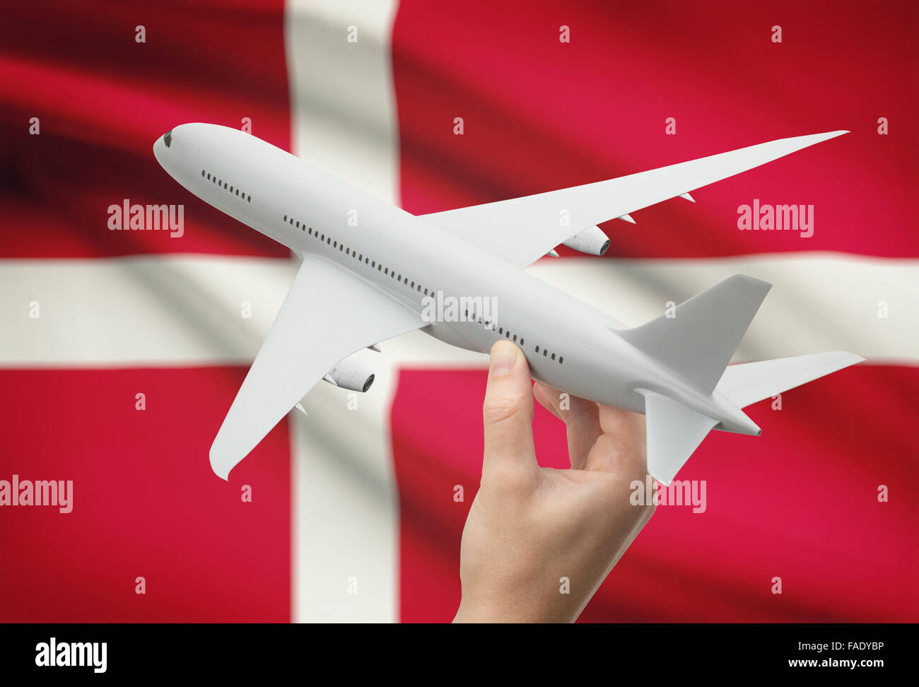 Airplane in hand with national flag on background - Denmark Stock Photo ...