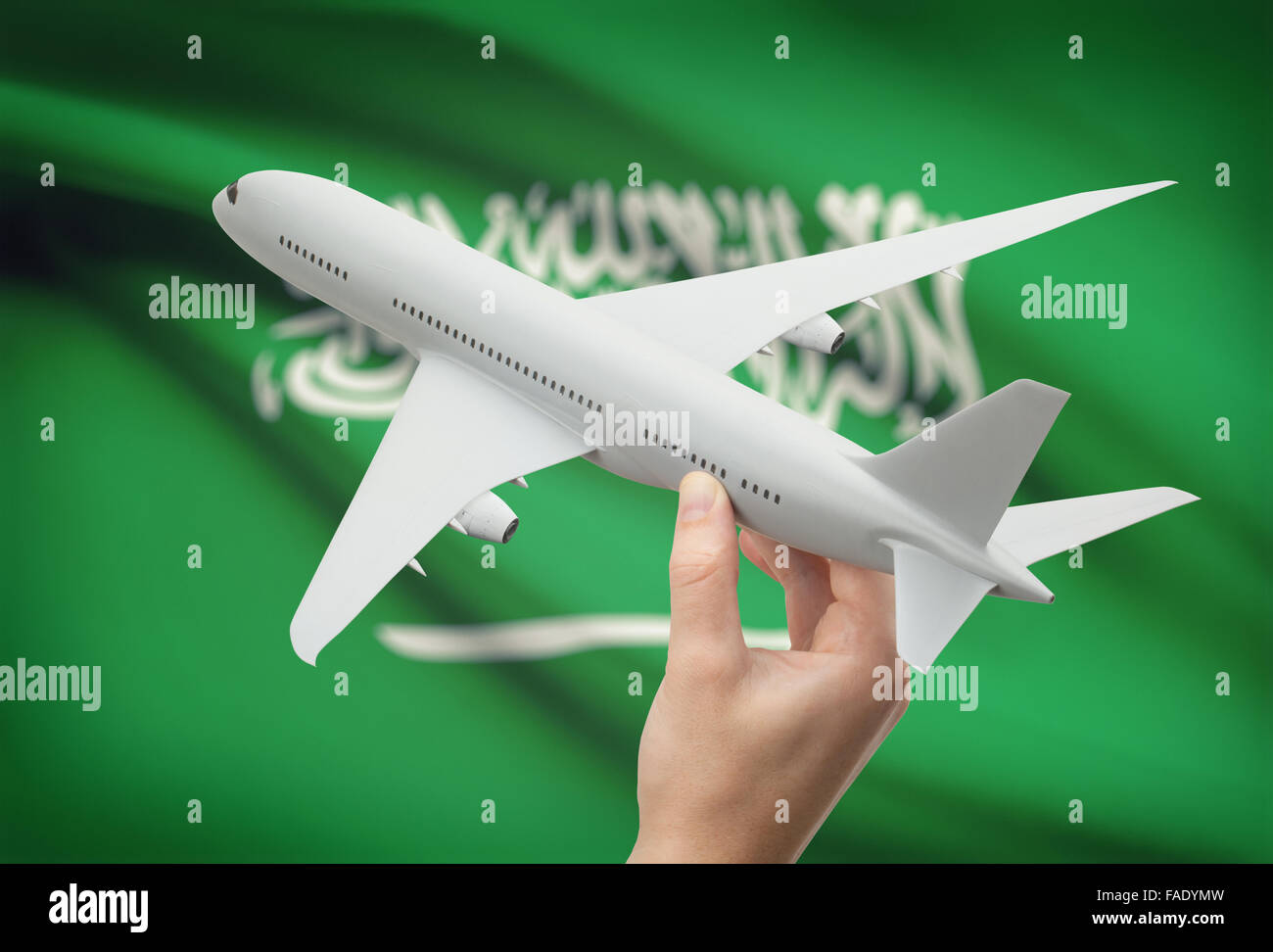 Airplane in hand with national flag on background - Saudi Arabia Stock ...