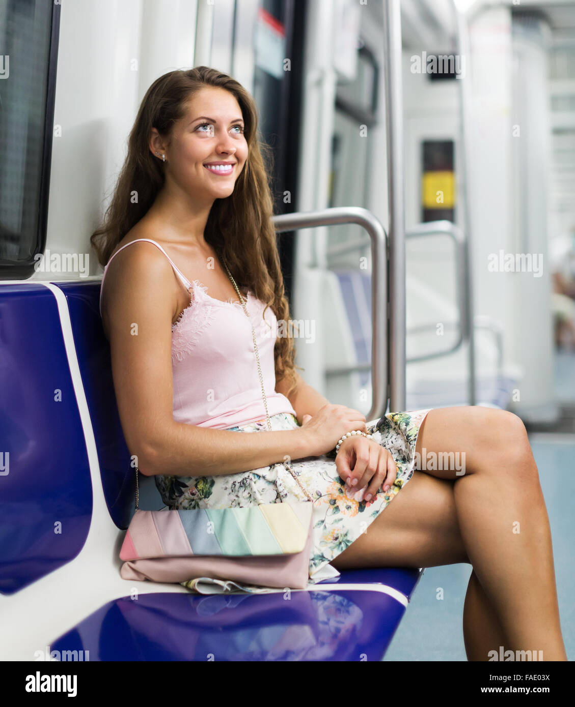 Smiling girl sitting inside train at metro Stock Photo - Alamy