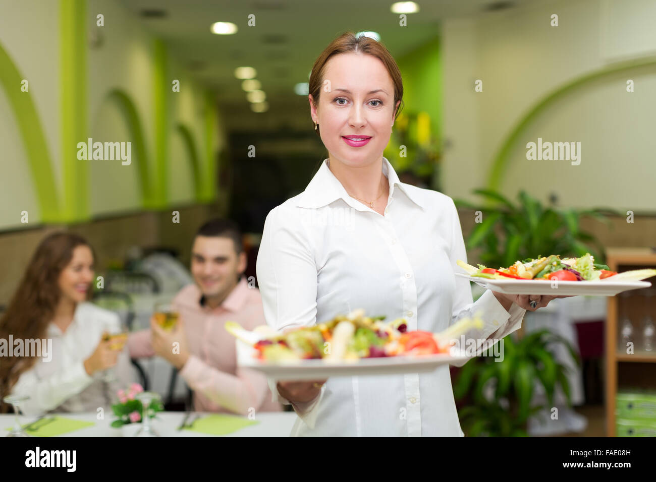 Positive waitress serving meal hi-res stock photography and images - Alamy