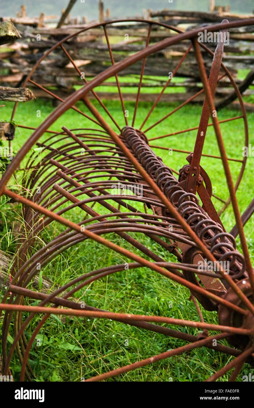 An old hay rake sets in a field at the pioneer village visitor center ...