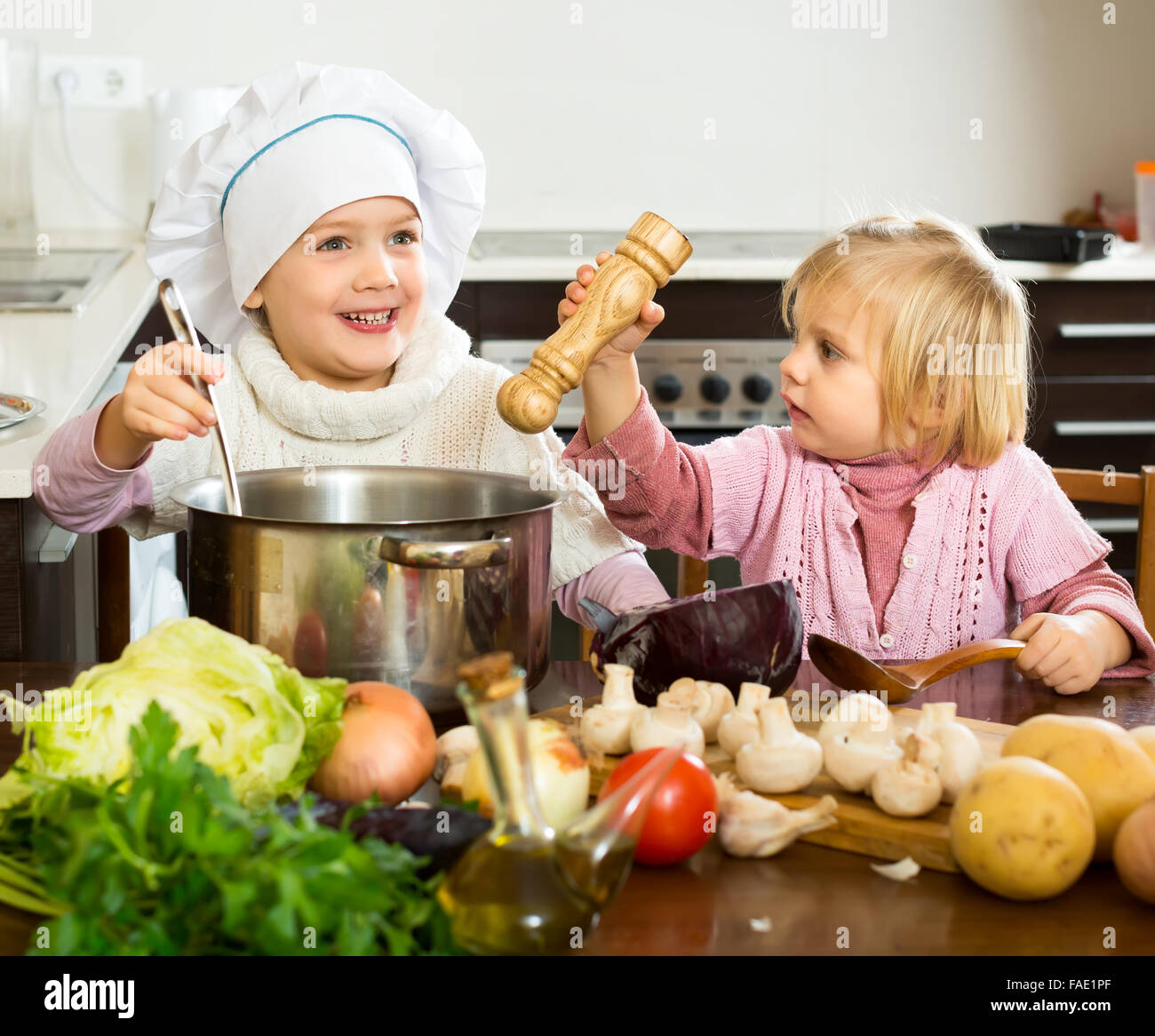 Sisters cooking vegetables in kitchen hi-res stock photography and ...