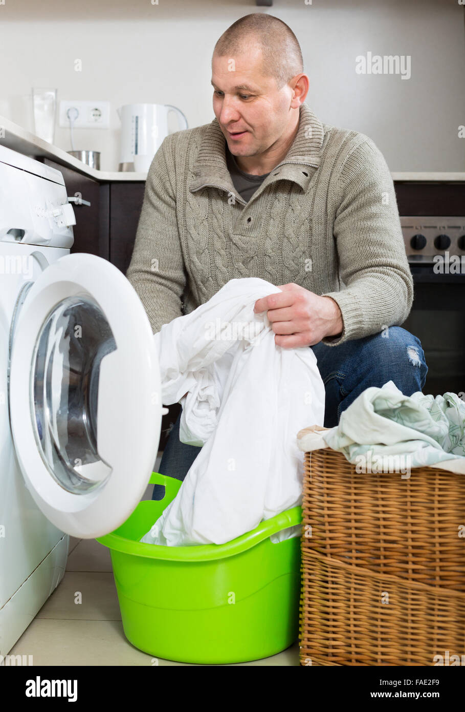 Home laundry. Ordinary man using washing machine at home Stock Photo ...