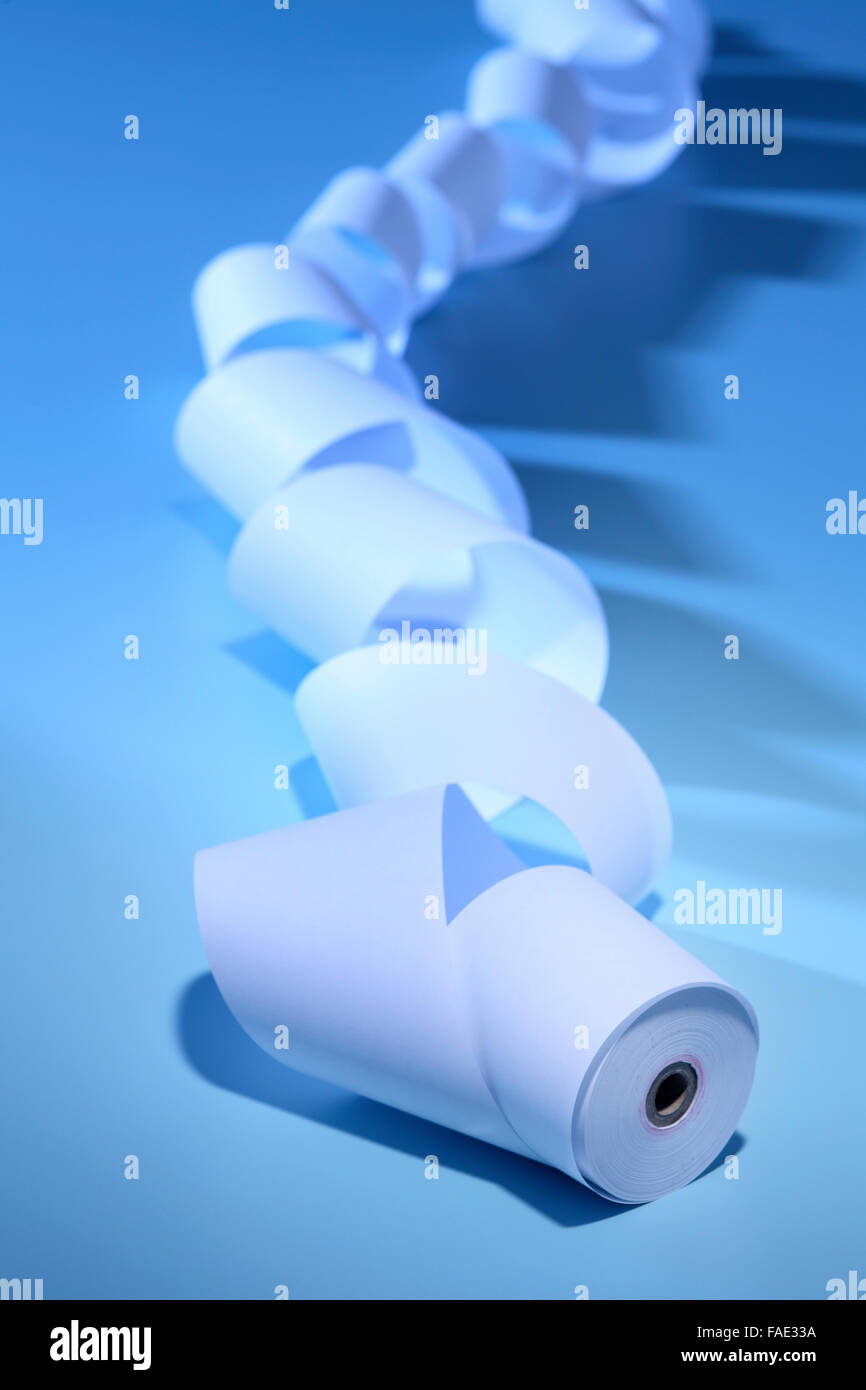 Roll of paper curling on the blue background Stock Photo - Alamy