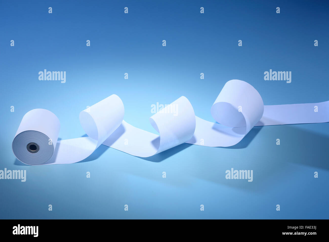 Roll of paper curling on the blue background Stock Photo - Alamy