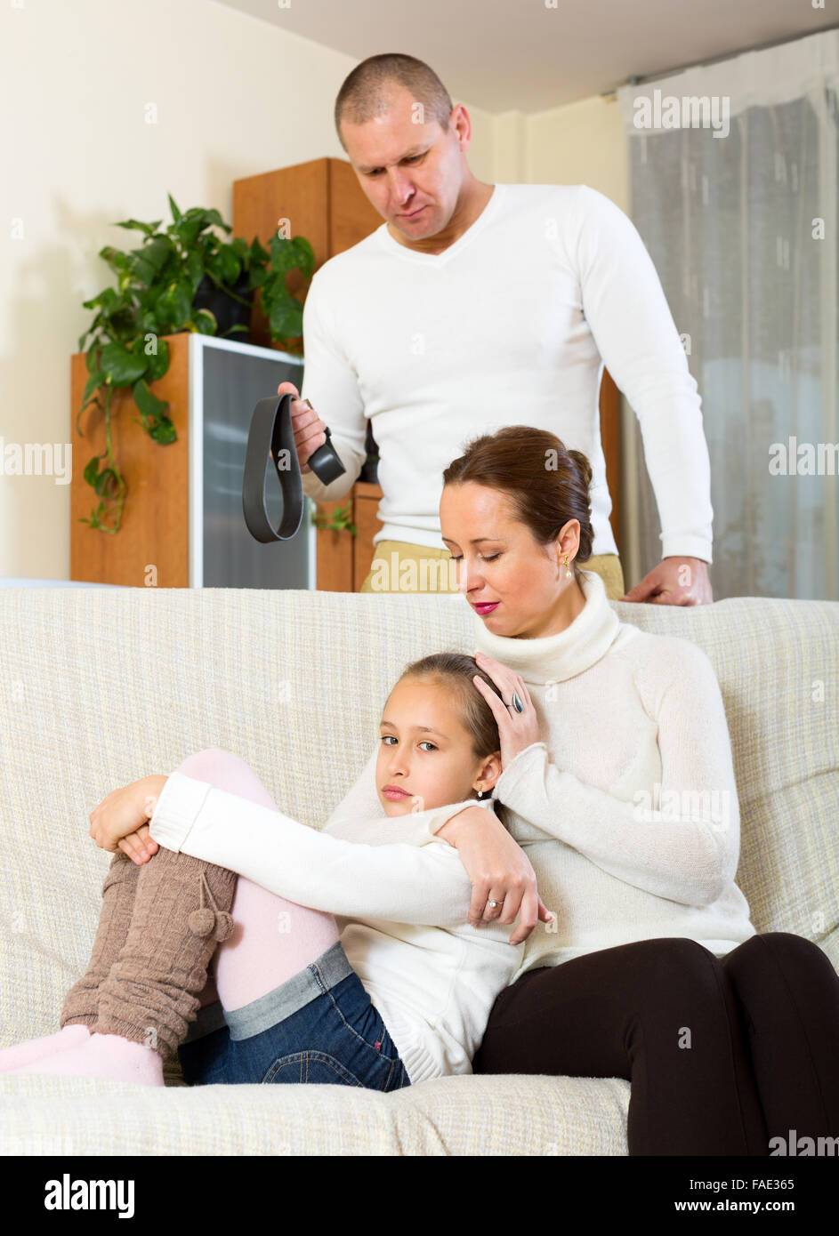 Young mother gives solace to crying small daughter and angry father ...